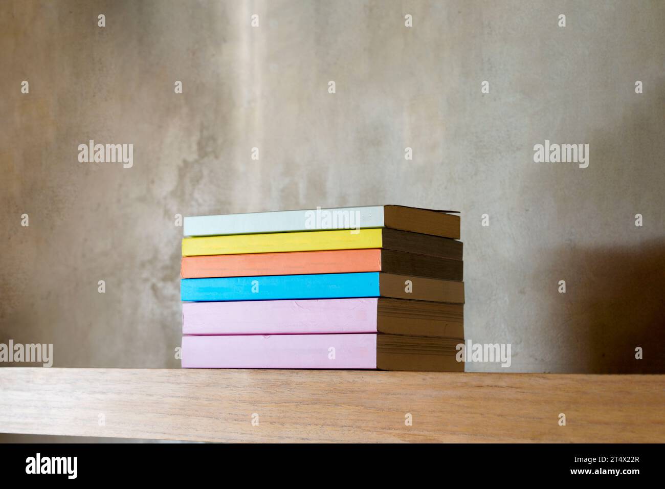 Stack of colorful books on floating wooden bookshelf. Education and ...