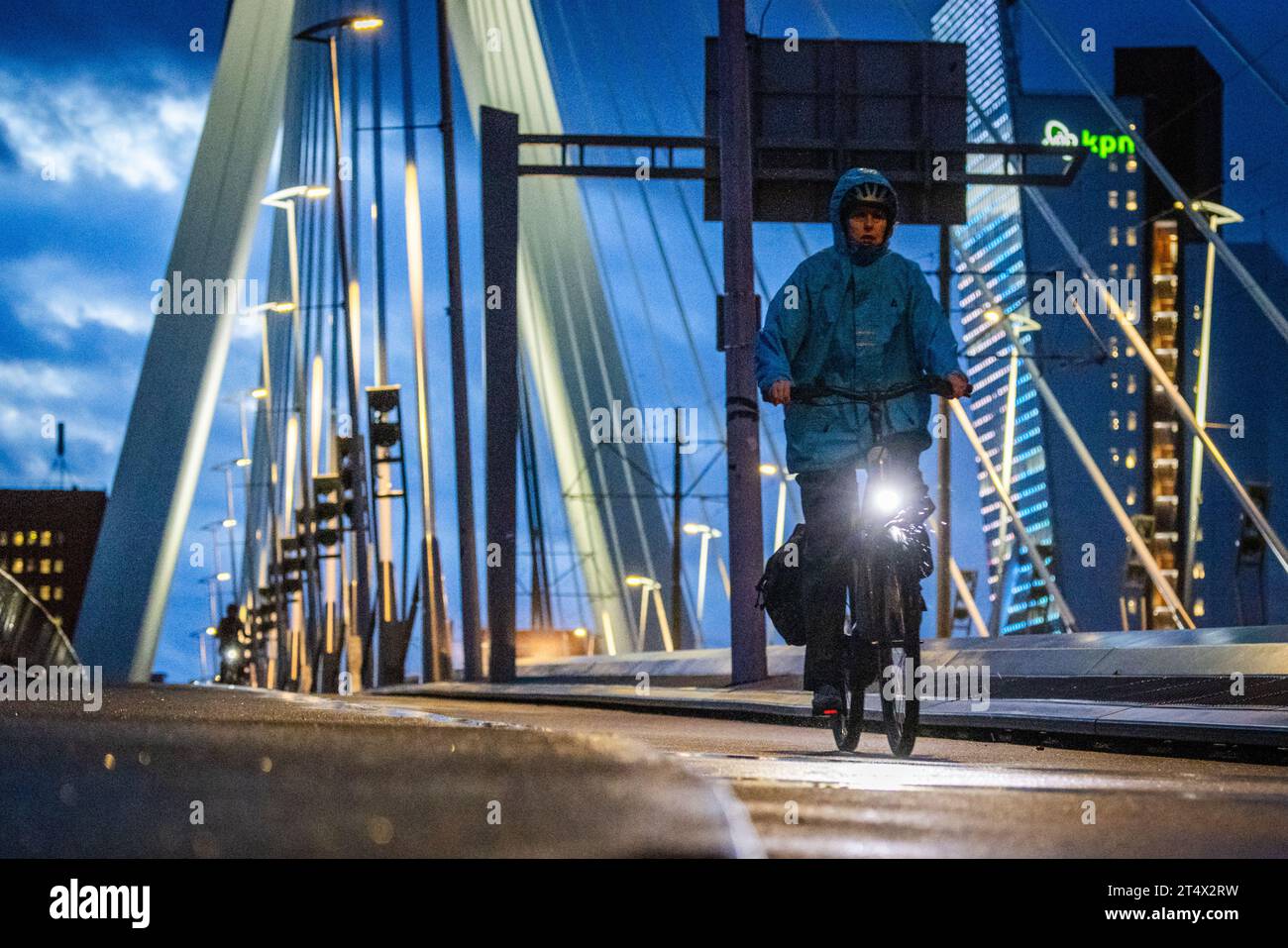 ROTTERDAM - A cyclist on the Erasmus Bridge during storm Ciaran. In a ...