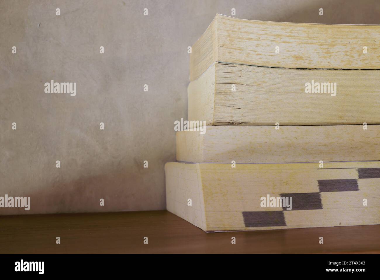 Stack of yellowish and vintage books on floating wooden bookshelf ...
