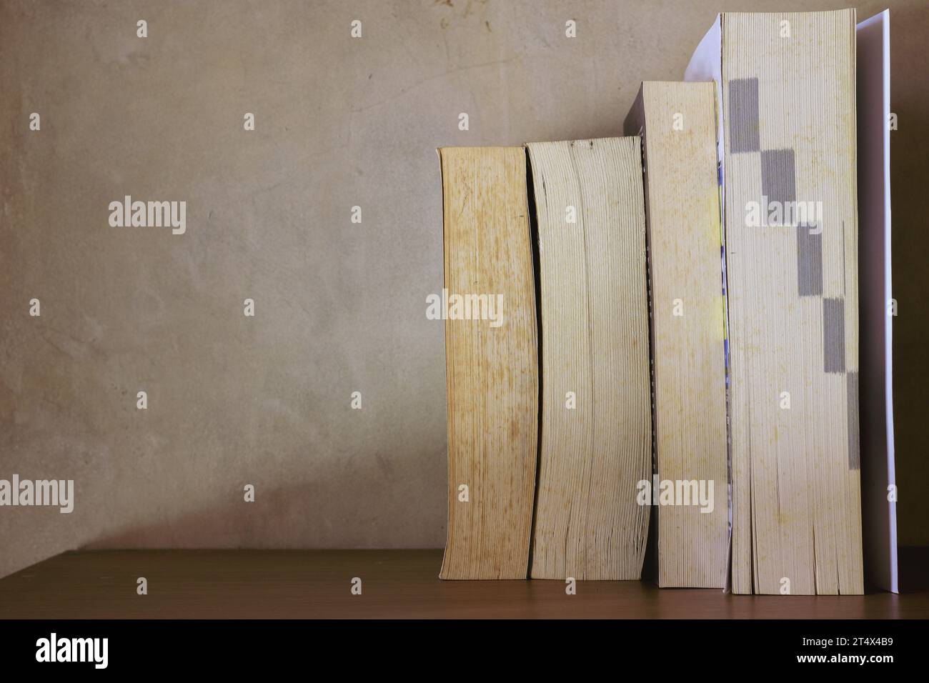 Stack of yellowish and vintage books on floating wooden bookshelf ...