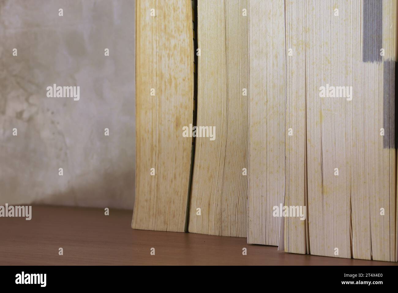 Stack of yellowish and vintage books on floating wooden bookshelf ...