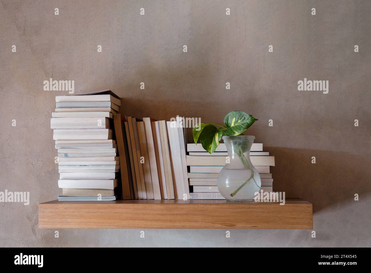 Stack of books on floating wooden bookshelf. Education and knowledge ...