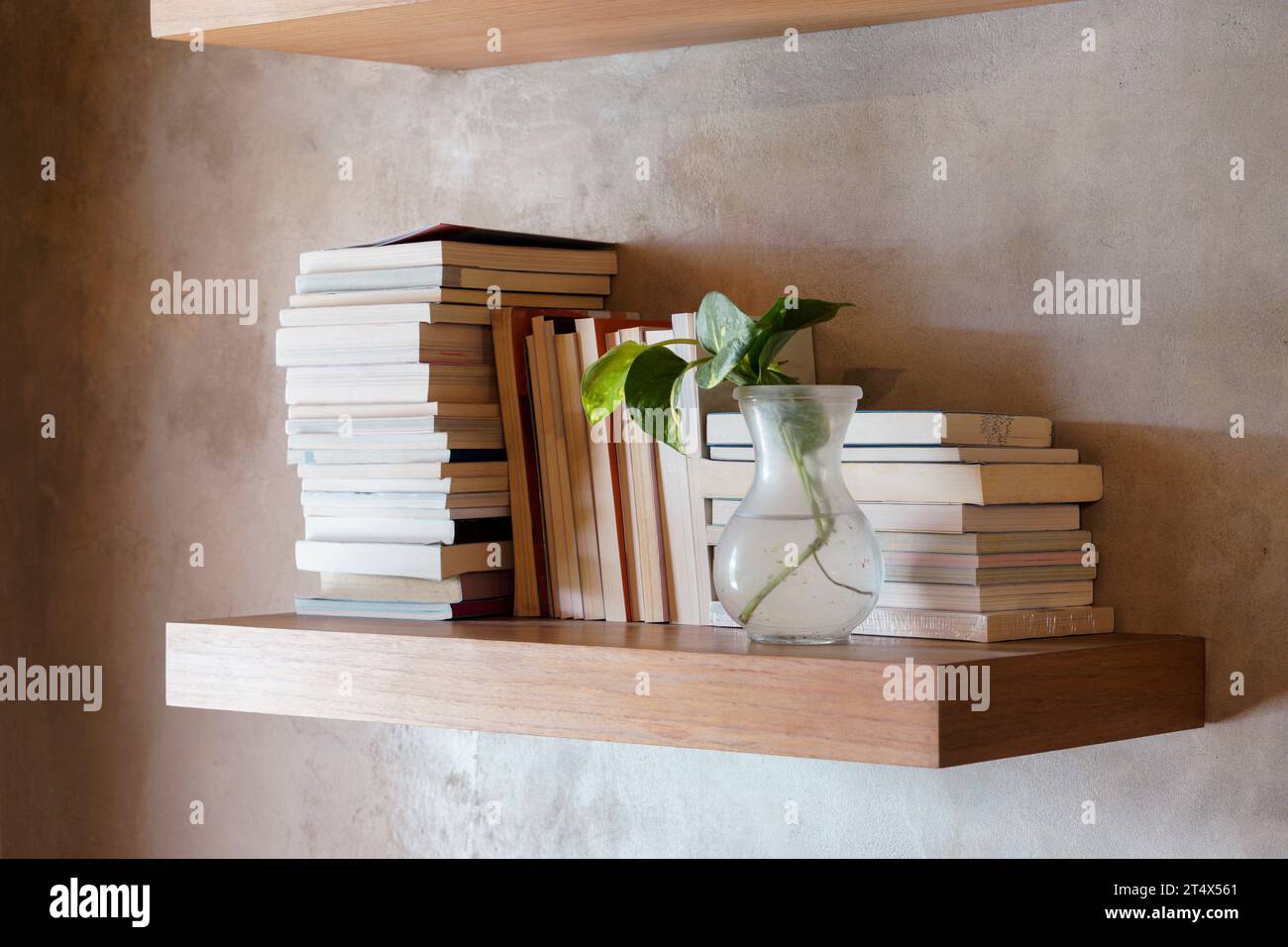 Stack of books on floating wooden bookshelf. Education and knowledge ...