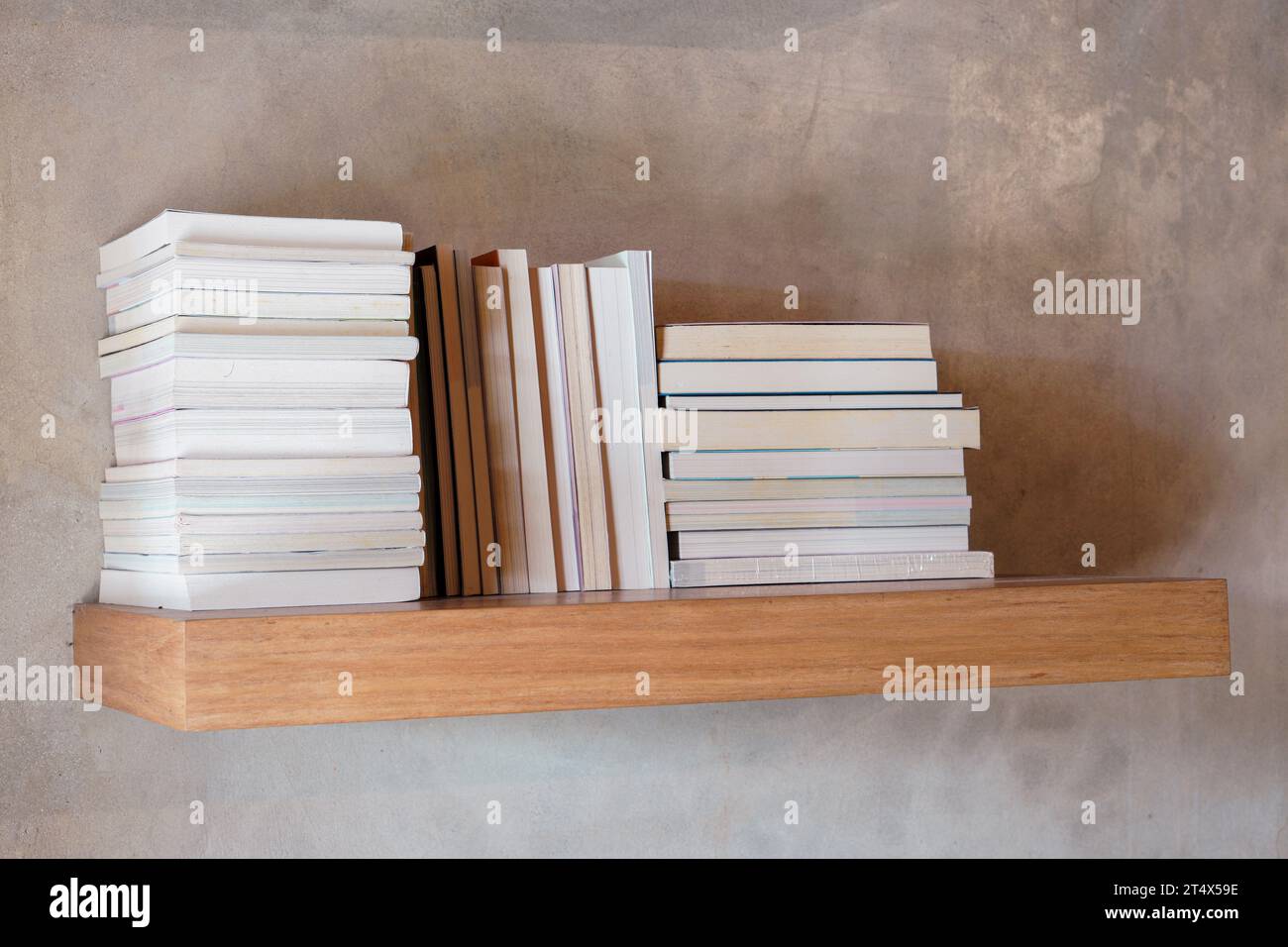 Stack of books on floating wooden bookshelf. Education and knowledge ...