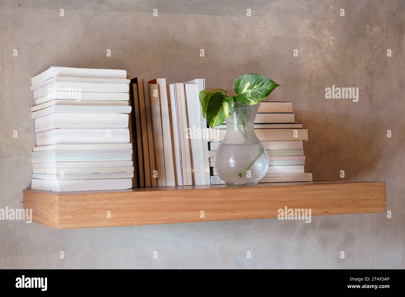 Stack of books on floating wooden bookshelf. Education and knowledge ...