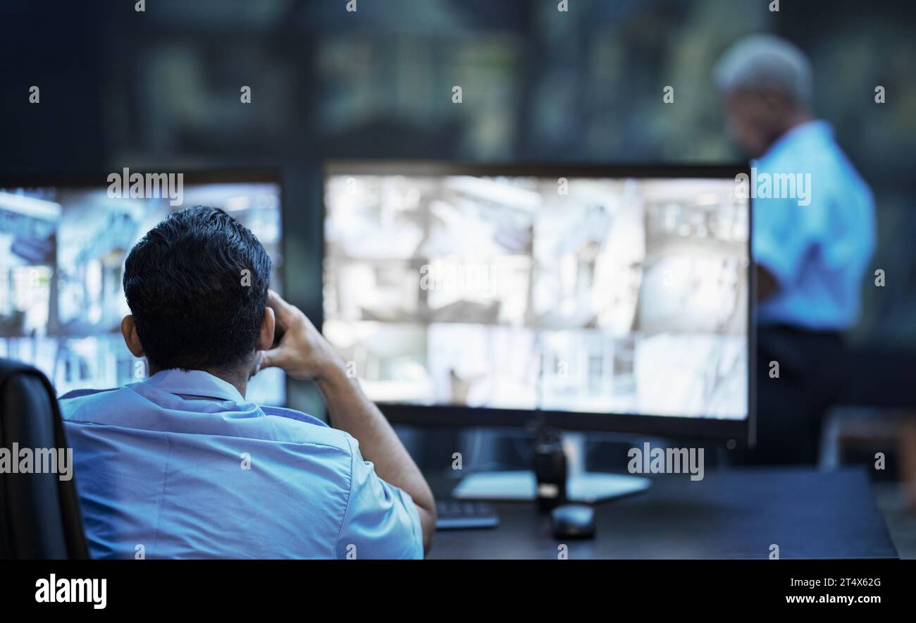 Security guard in control room, man checking cctv screen in ...
