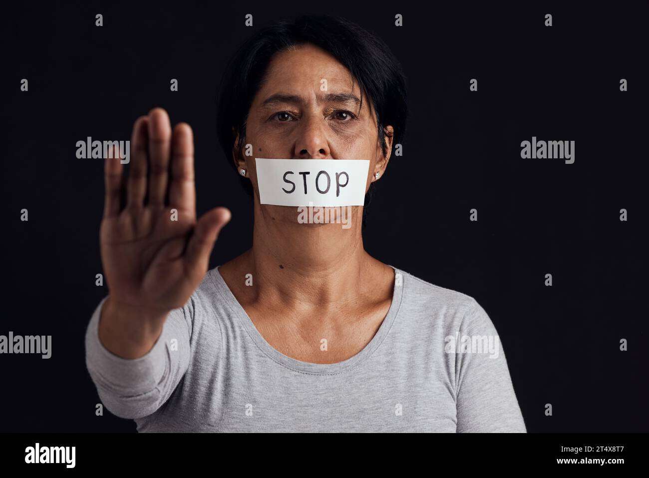 Portrait, stop and palm with a woman in studio on a black background ...