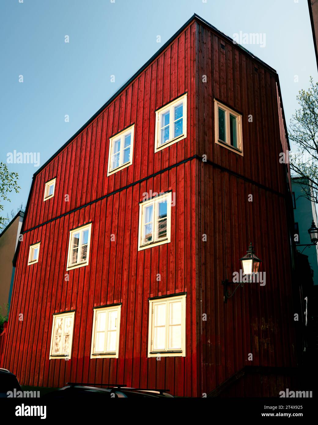 Basking in the warmth of a sunny day, a charming red Nordic house with ...