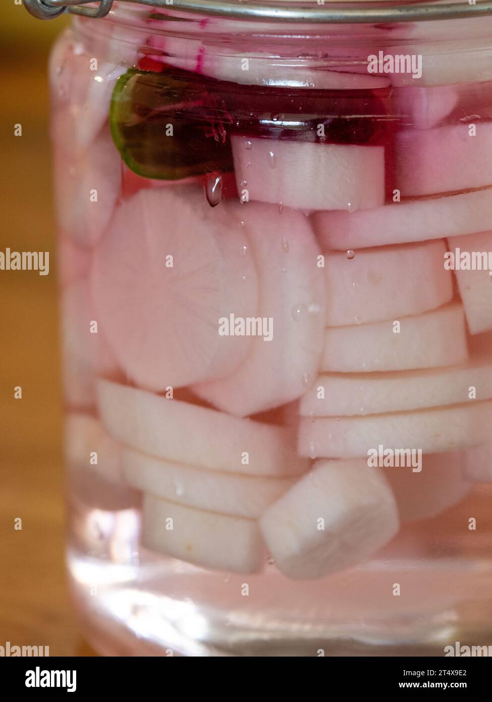 Pickled Daikon Radishes in a glass jar with a slice of beetroot Stock ...