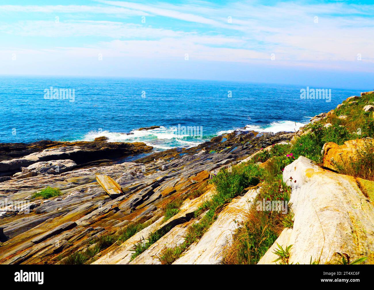 A scenic coastal landscape featuring a rugged shoreline with an ...
