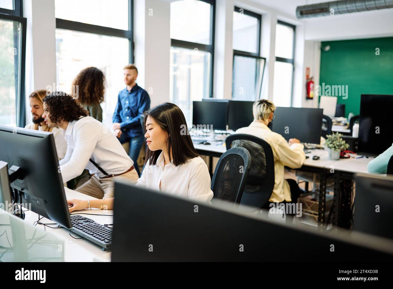 Coworking space with multi-ethnic young people working Stock Photo - Alamy