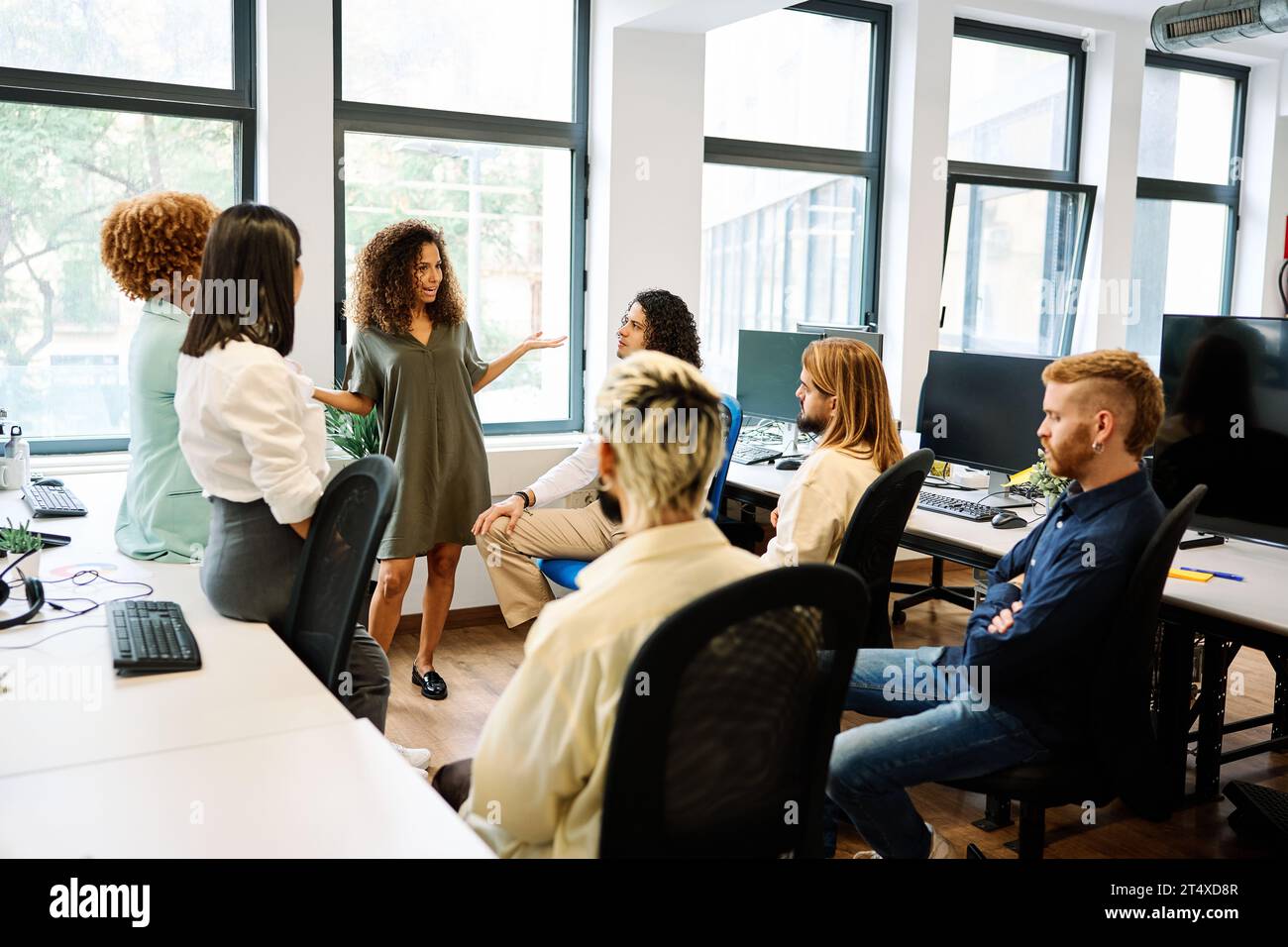 Leader speaking to colleagues in a coworking Stock Photo - Alamy