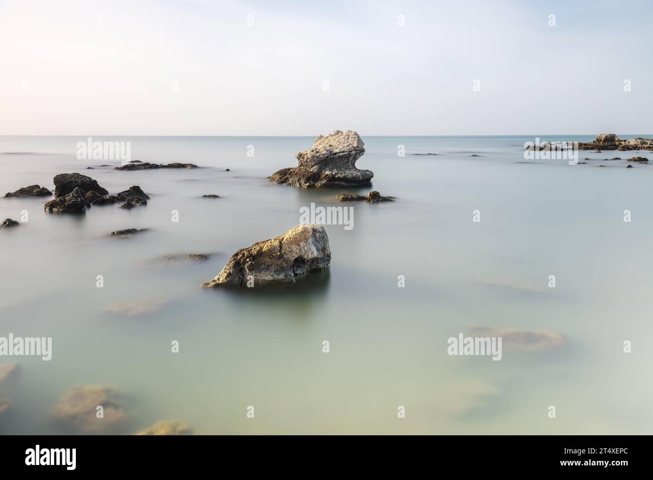 Minimalist fine art view of rocks in the sea taken with long exposure ...