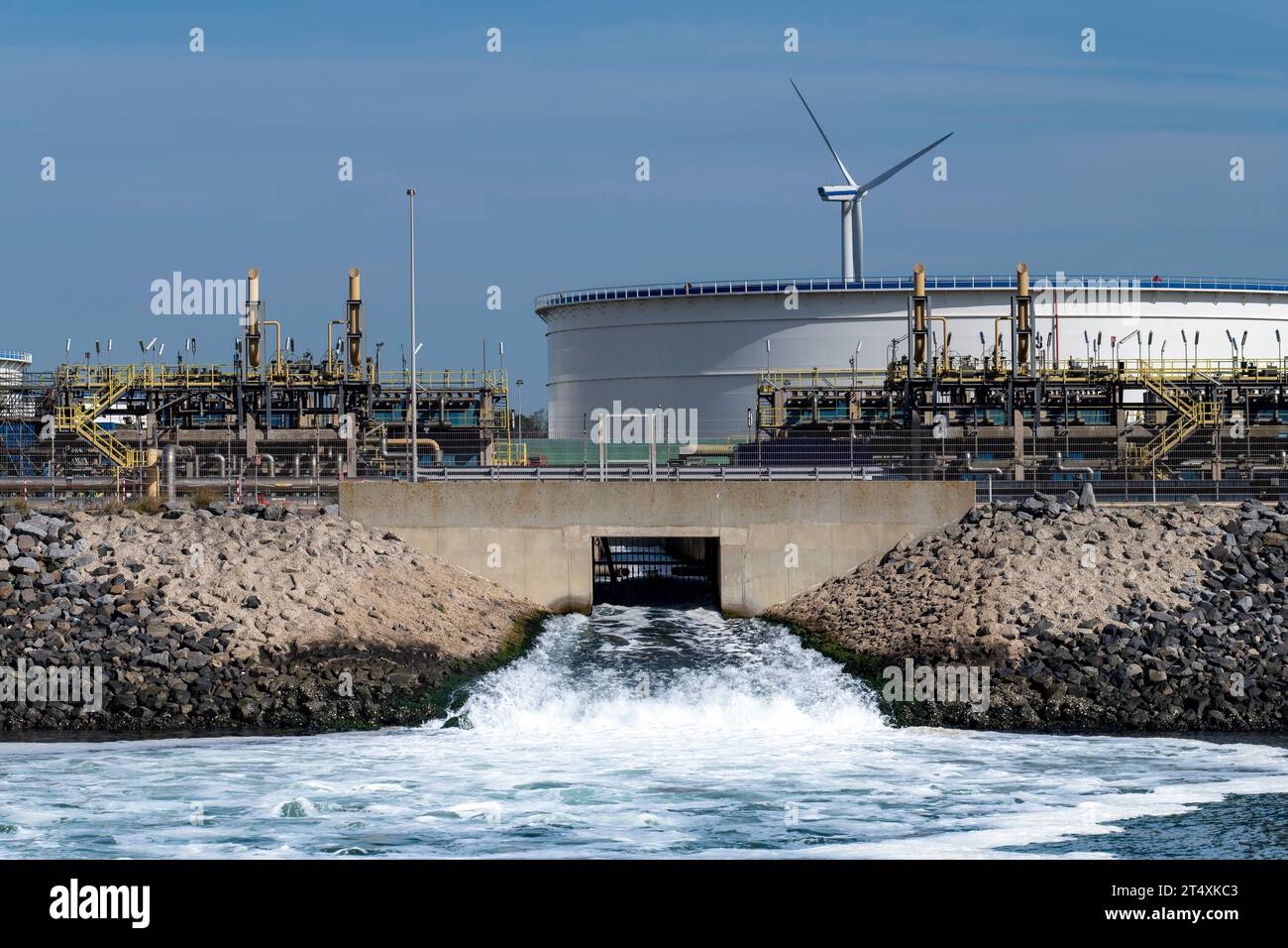 Large white LNG storage tank at an LNG plant with discharge of treated ...