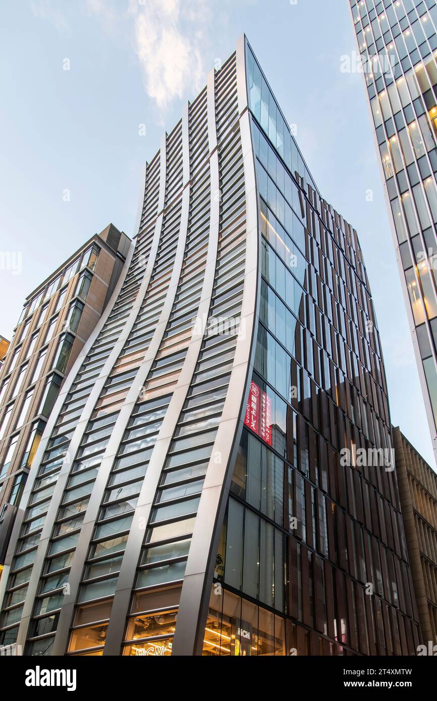 Tokyo, Japan-March 31, 2023; Low angle view of the façade of a curved ...