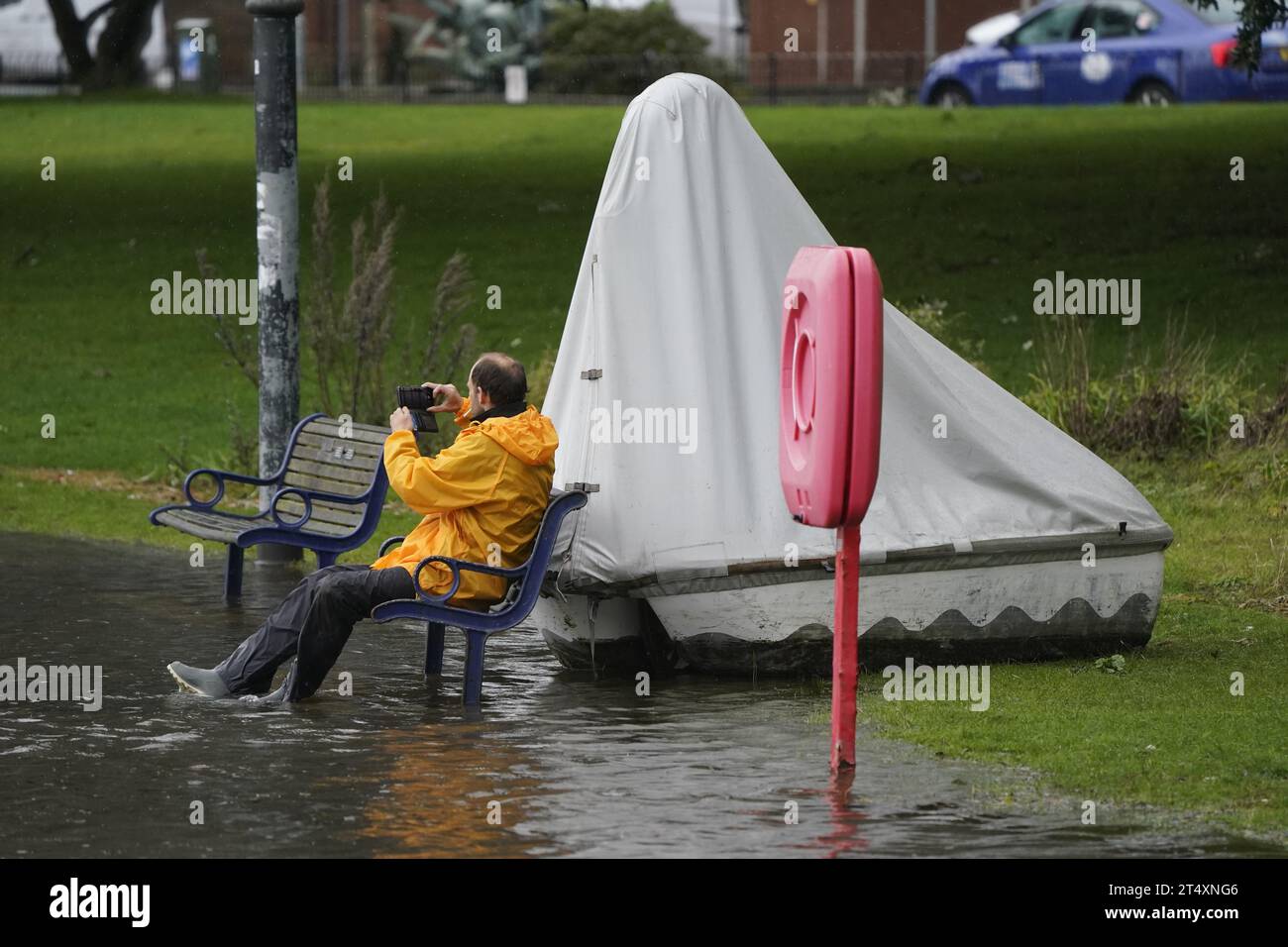 A person sitting on a submerged bench at Canoe Lake, Southsea ...