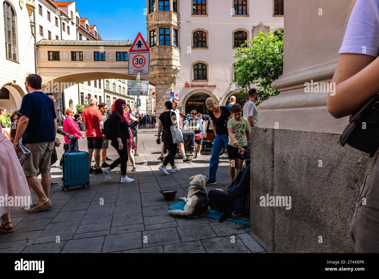 Munich, Germany - July 22, 2023: People feed homeless man and his dog ...