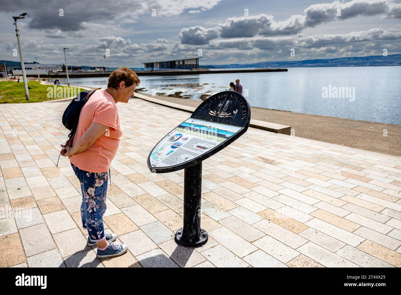 Tourist looking at one of the Clyde Sea Lochs Trail information panel's ...