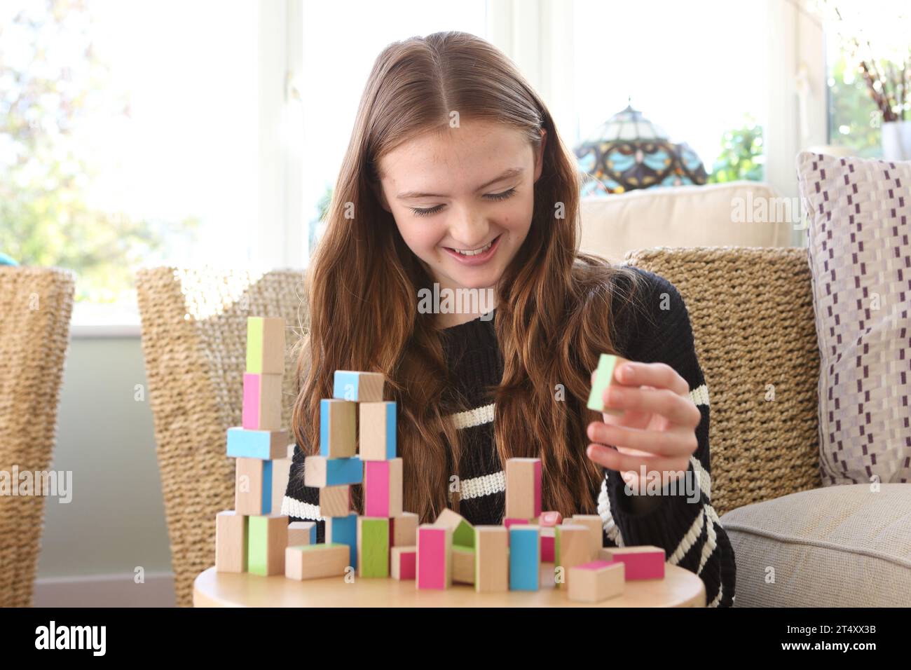 Girl constructing a wall of wooden blocks and building a tower Stock ...