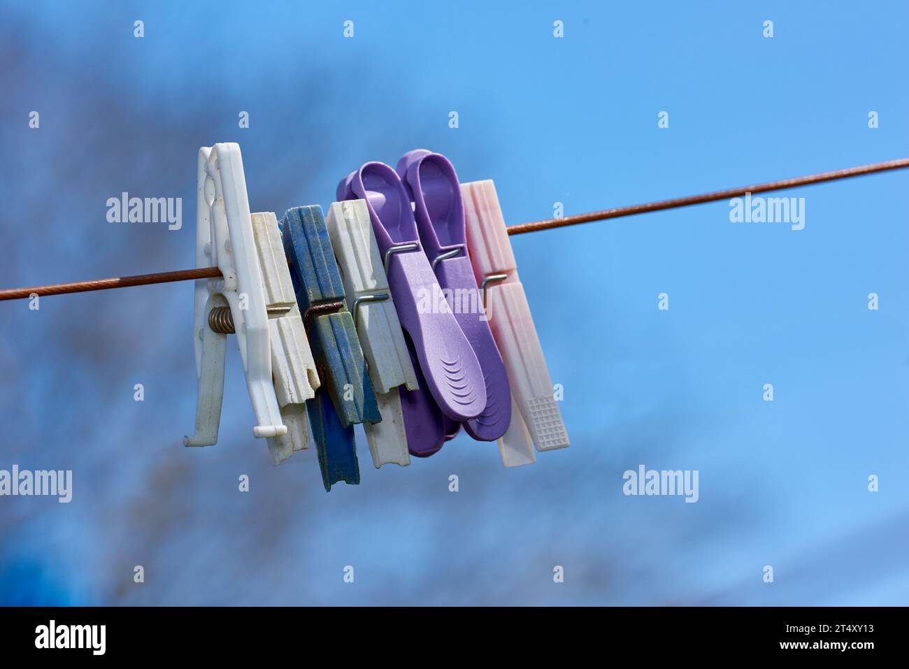 Old washing line with broken pins hanging outside against a blurred ...
