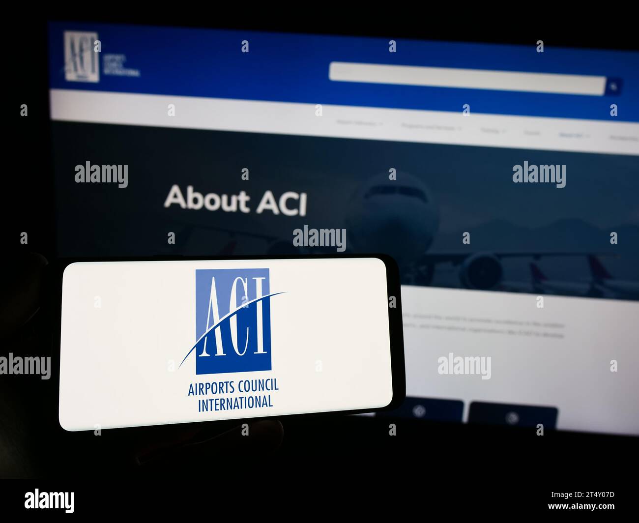 Person holding smartphone with logo of organization Airports Council ...
