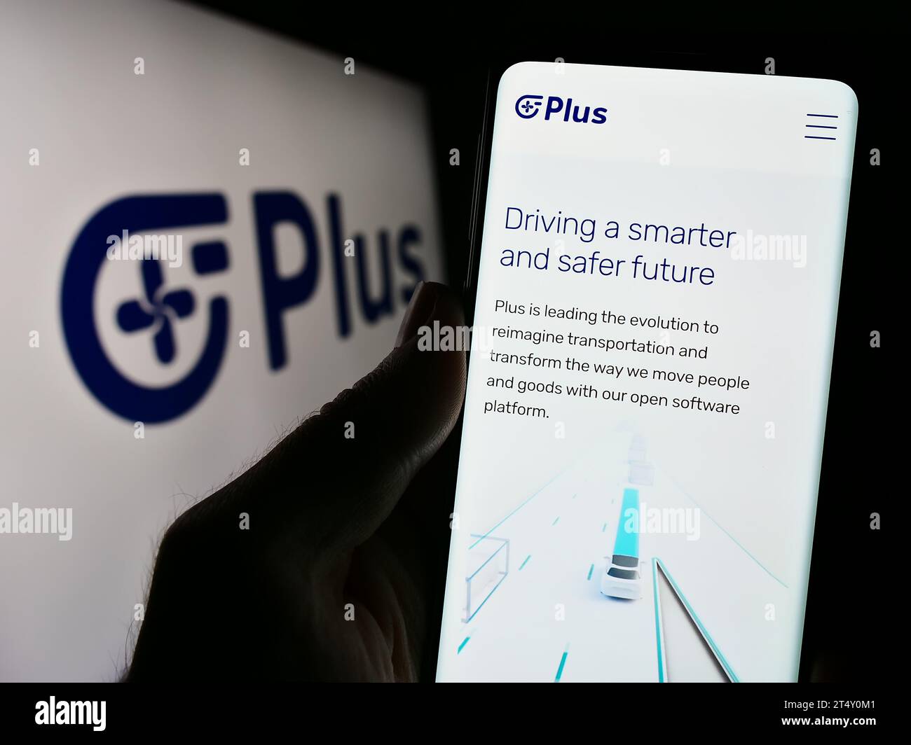 Person holding cellphone with webpage of US autonomous trucking company PlusAI Inc. in front of ...