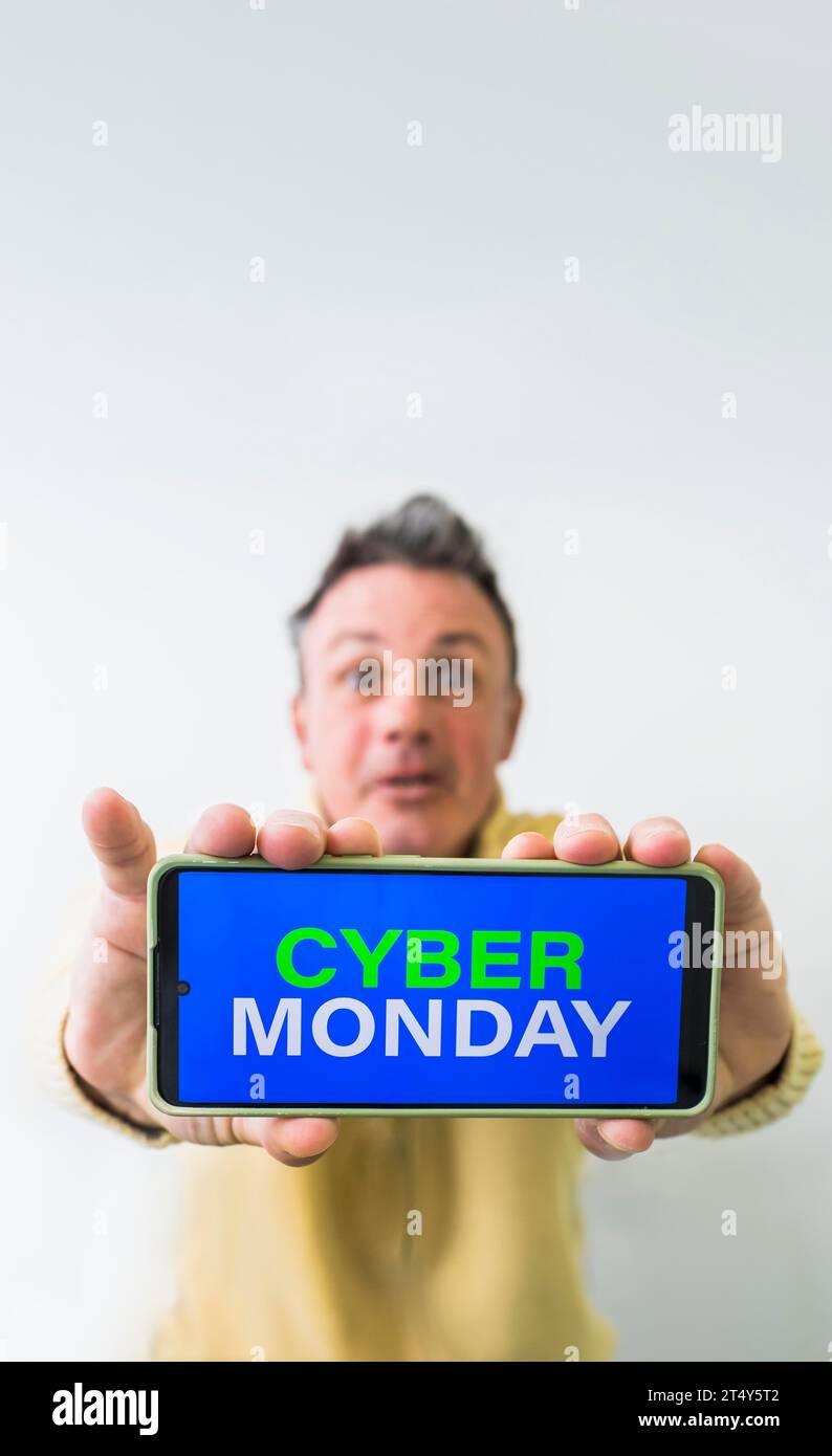 Crazy man holding mobile phone with Cyber Monday advertisement on the ...