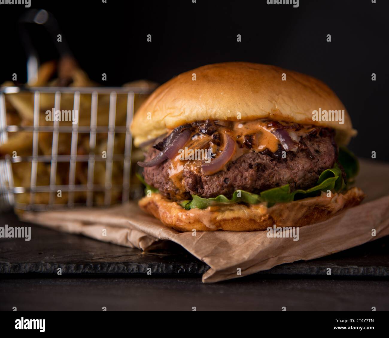 Juicy Homemade burger with lettuce onions, and chipotle sauce in a ...