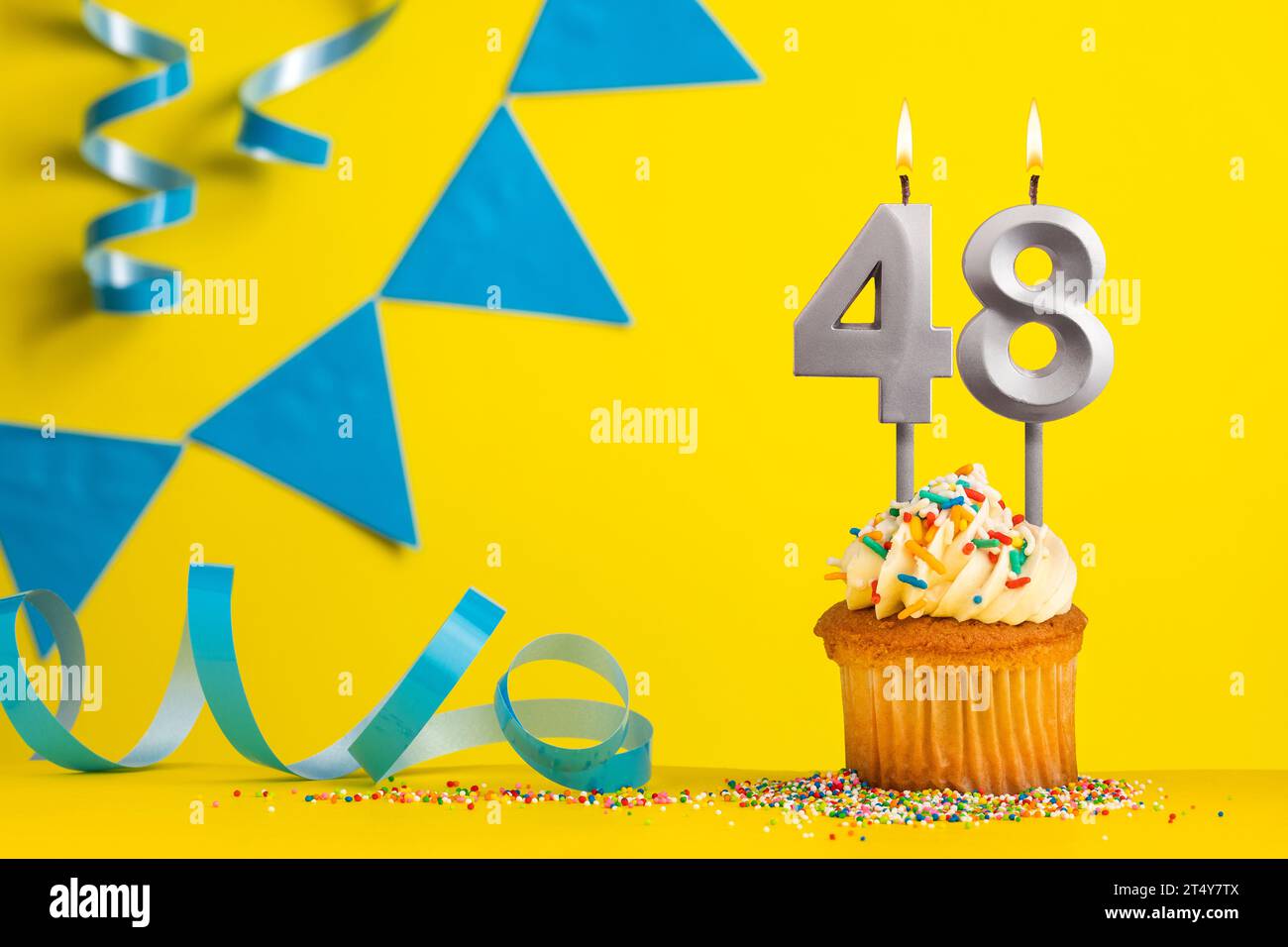 Lighted birthday candle number 48 - Yellow background with blue ...