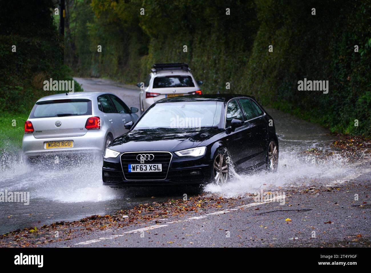 Cars driving through rainwater running off a field in Exeter as Storm ...