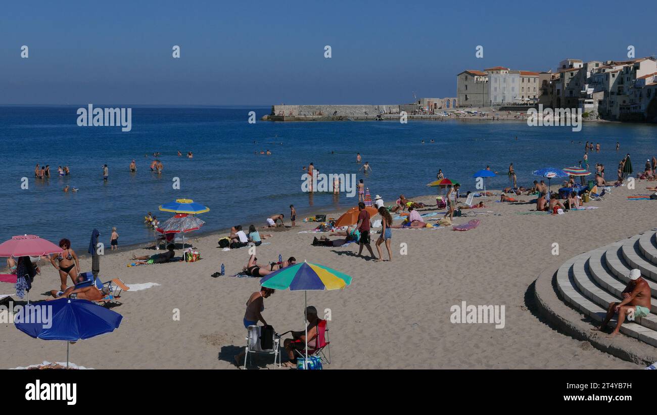 Sunbathers on beach at Cefalu on the Italian Island of Sicily. Summer ...