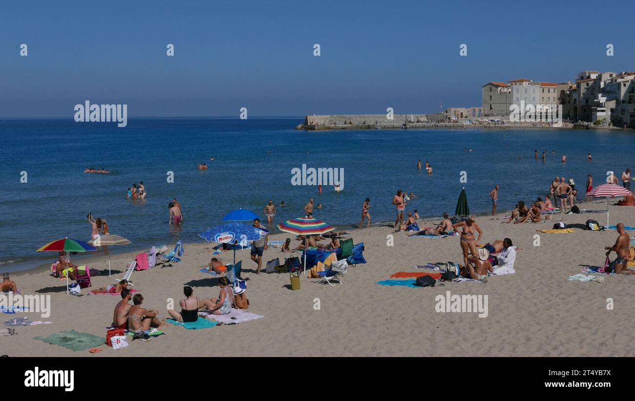 Sunbathers on beach at Cefalu on the Italian Island of Sicily. Summer ...