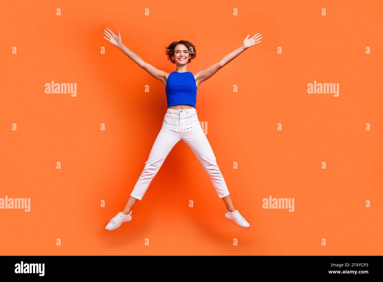 Full size portrait of overjoyed energetic girl jumping raise hands make ...
