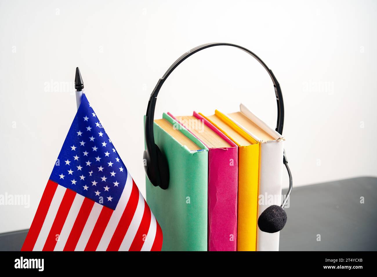 USA flag with pile of books against white background Stock Photo - Alamy