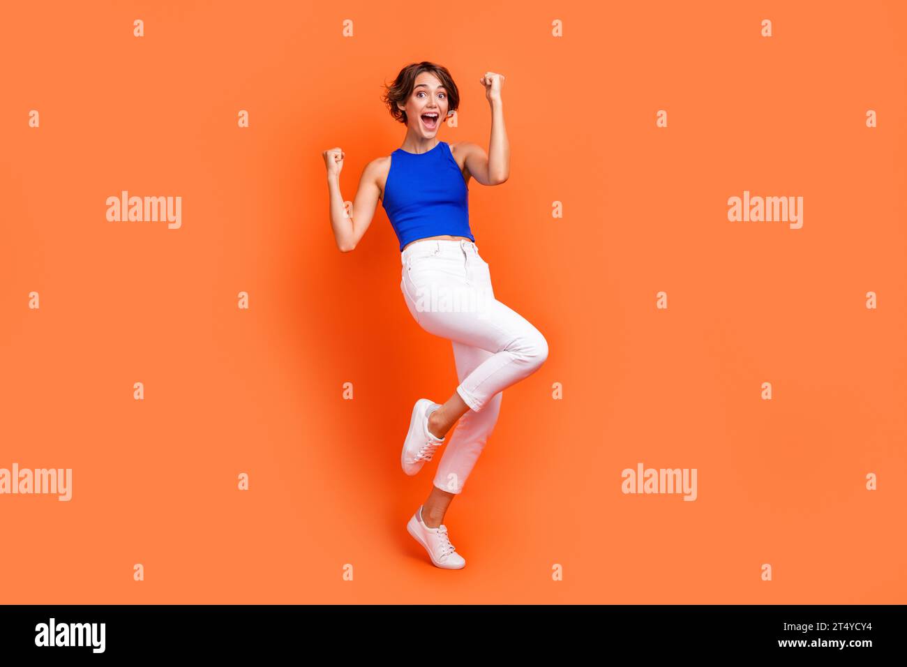 Full size portrait of funky overjoyed girl raise fists shout yes hooray ...