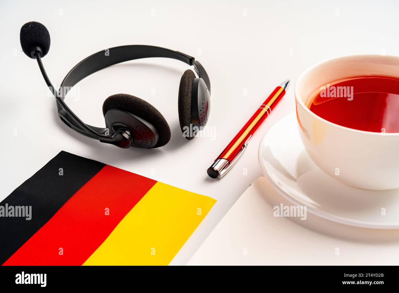 Notepad with German flag and headphones on white background. German ...