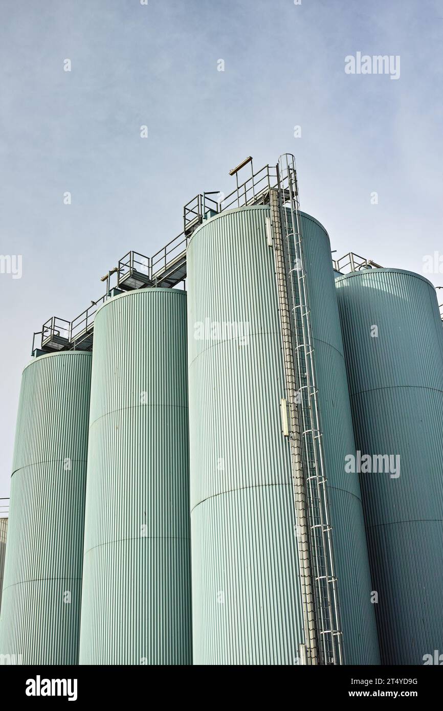 Silo storage tankers against a gray sky in Danish oil industry. large ...