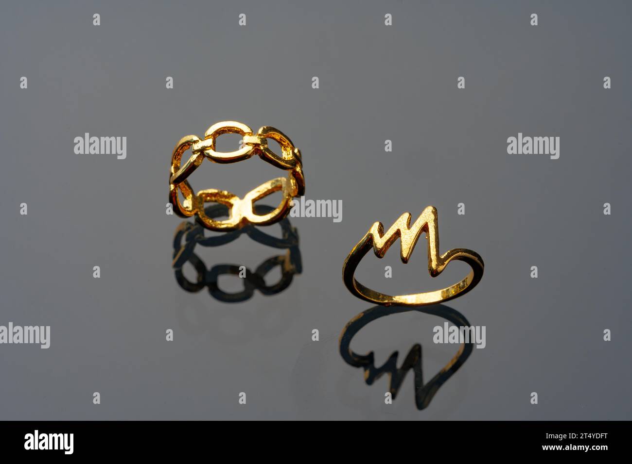 Two golden rings on glass background close up Stock Photo - Alamy