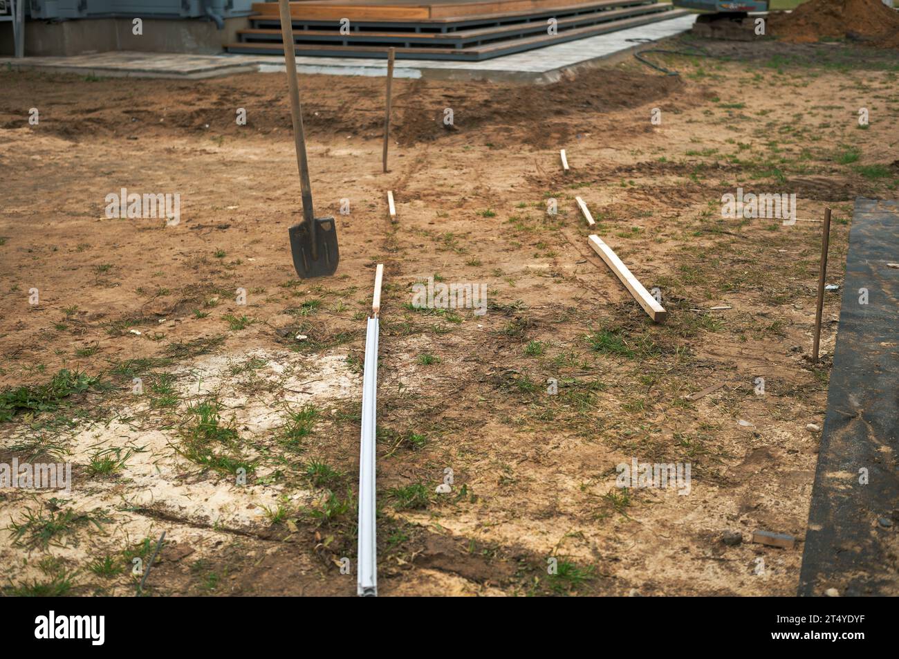 planning a footpath with sticks and spade, outdoor shot, no people ...