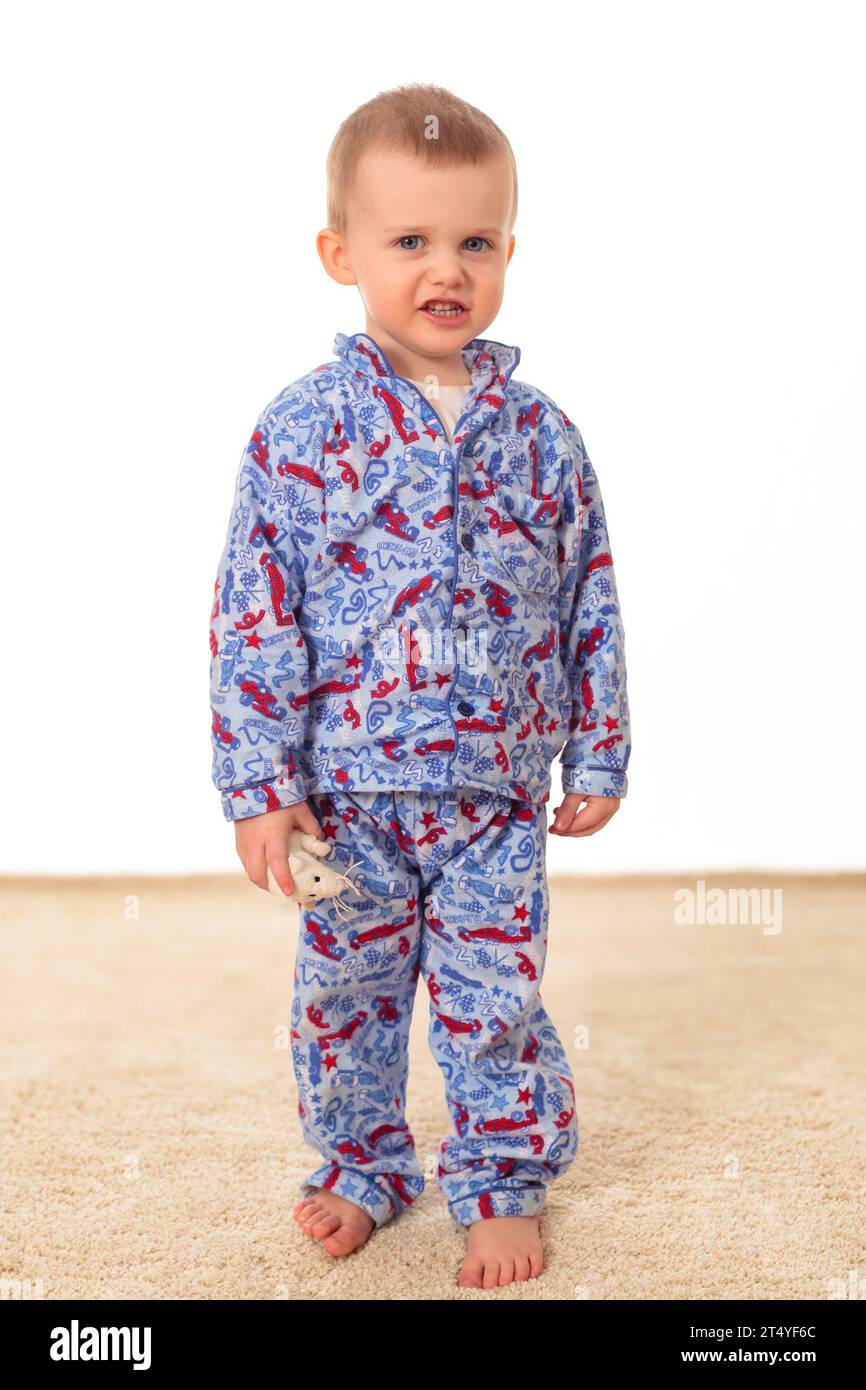 Portrait of cute young boy holding a cuddly toy mouse pulling a funny ...