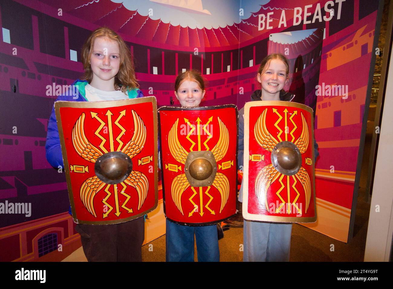 Three children sisters try Roman Shield dressing up; interior / inside ...
