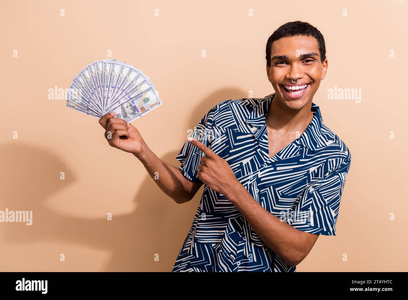 Photo of positive rich man wear trendy print clothes hold money rejoice ...