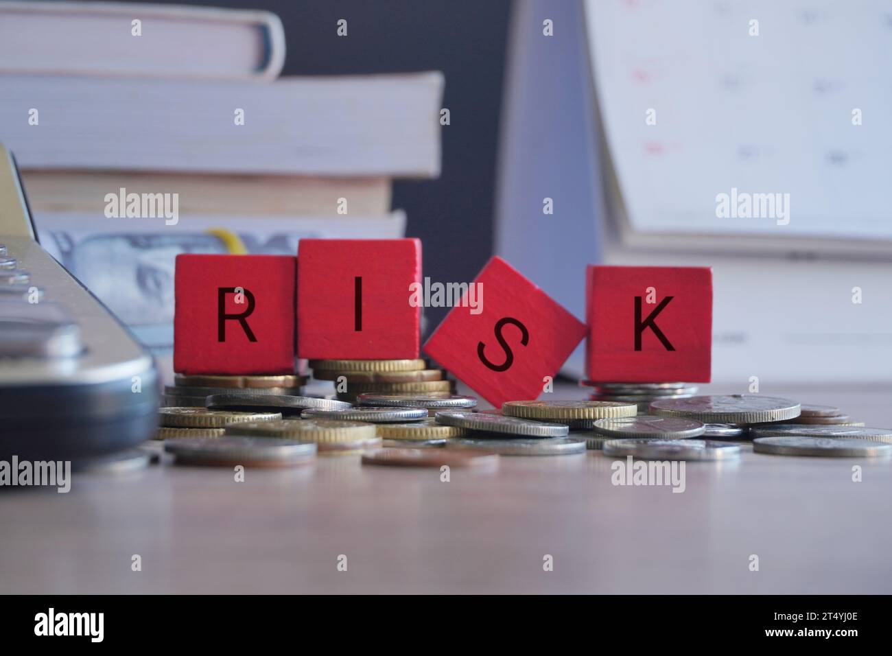 Wooden cubes with text RISK surrounded by calculator and money. Risk in ...