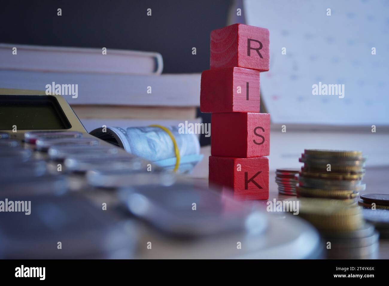Wooden cubes with text RISK surrounded by calculator and money. Risk in ...