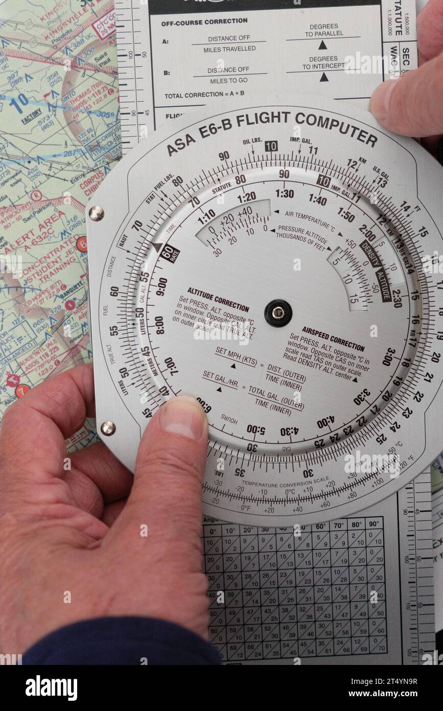 A pilot plots a flight on a sectional map for a vector from one airport ...