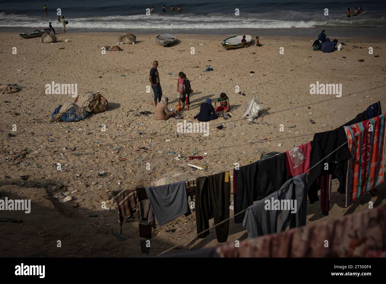 Palestinians dry their clothes after washing them with seawater at the ...