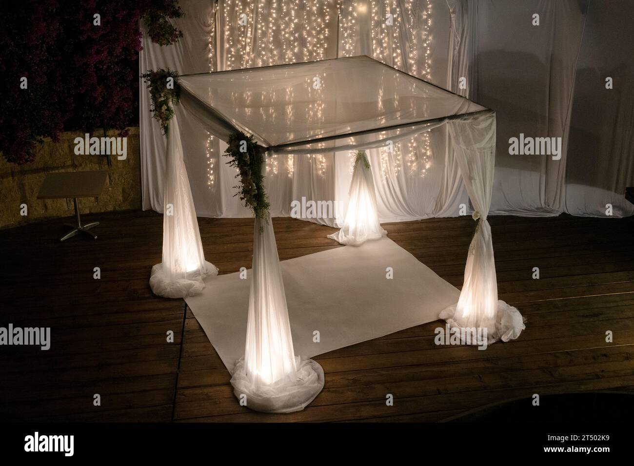 A chuppah or canopy of white lace fabric is prepared for a Jewish ...