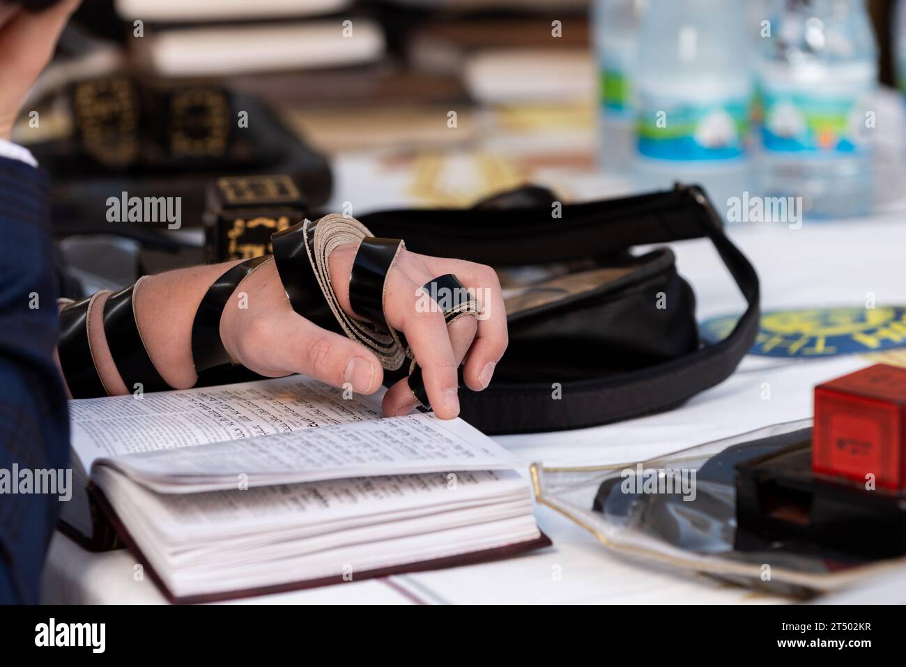 A man prays the Jewish morning service from a siddur prayer book while ...