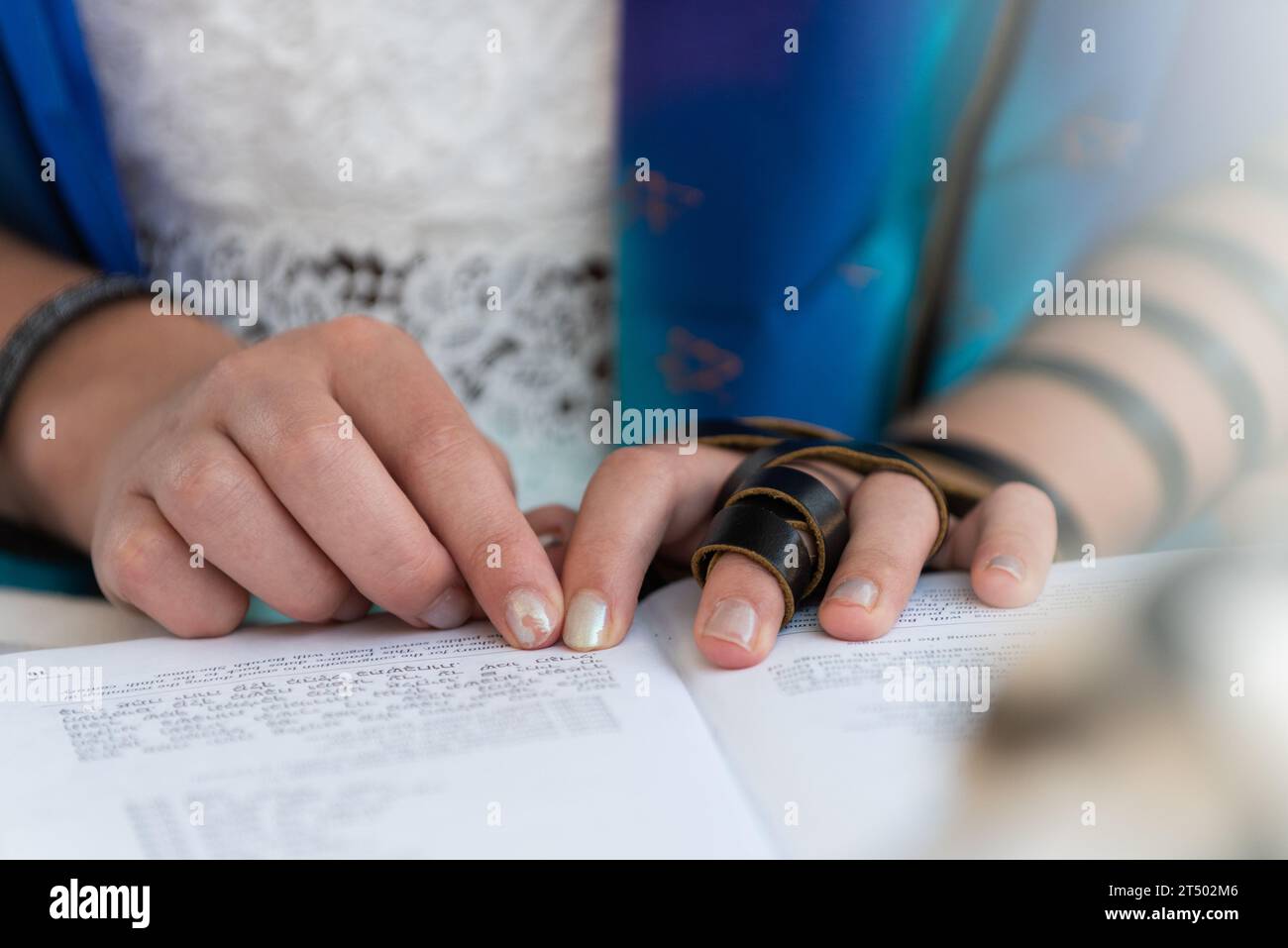 A bat mitzvah young woman prays the Jewish morning service from a ...