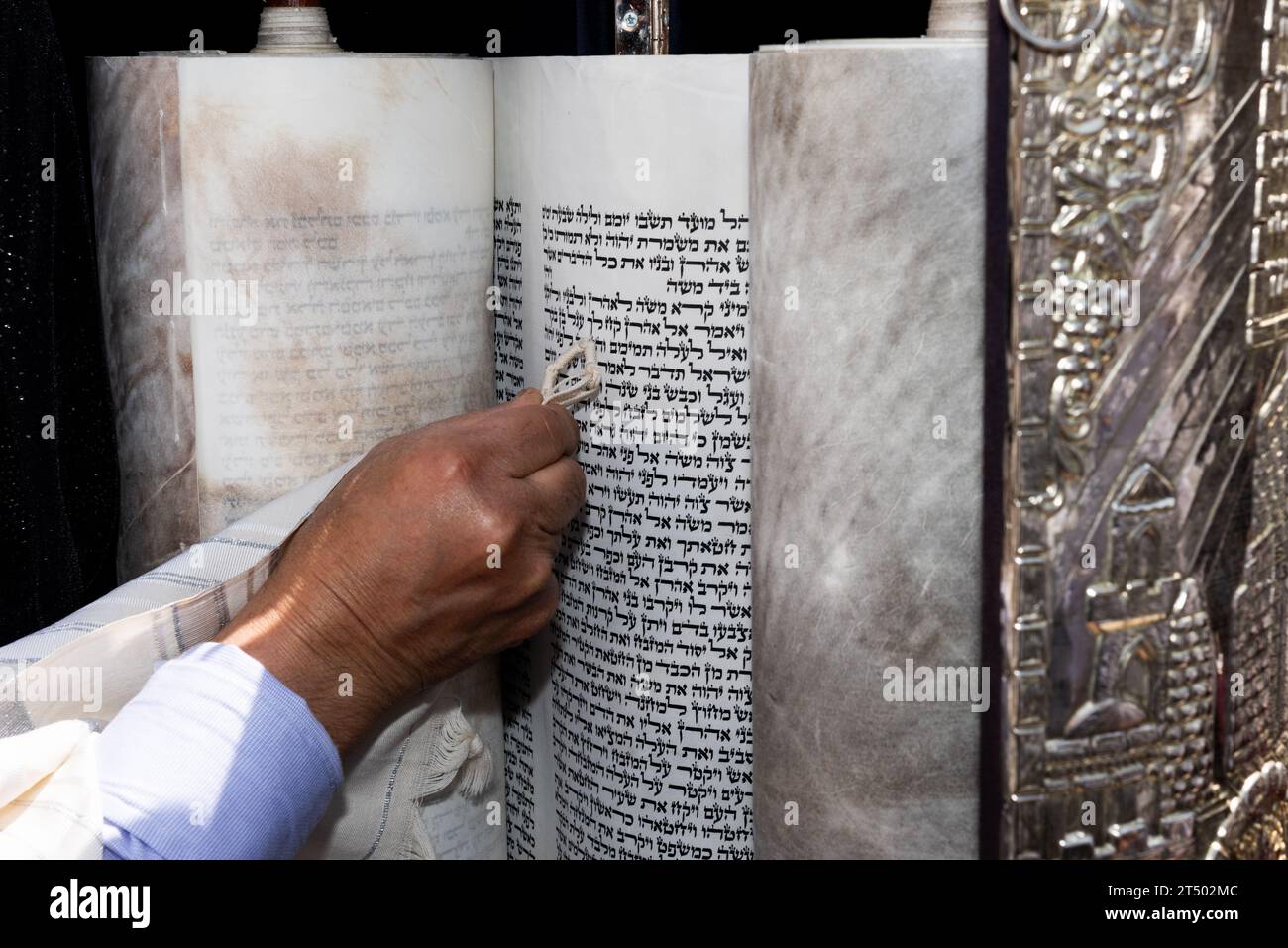 A reader uses the strings of his prayer shawl to guide his eyes across ...